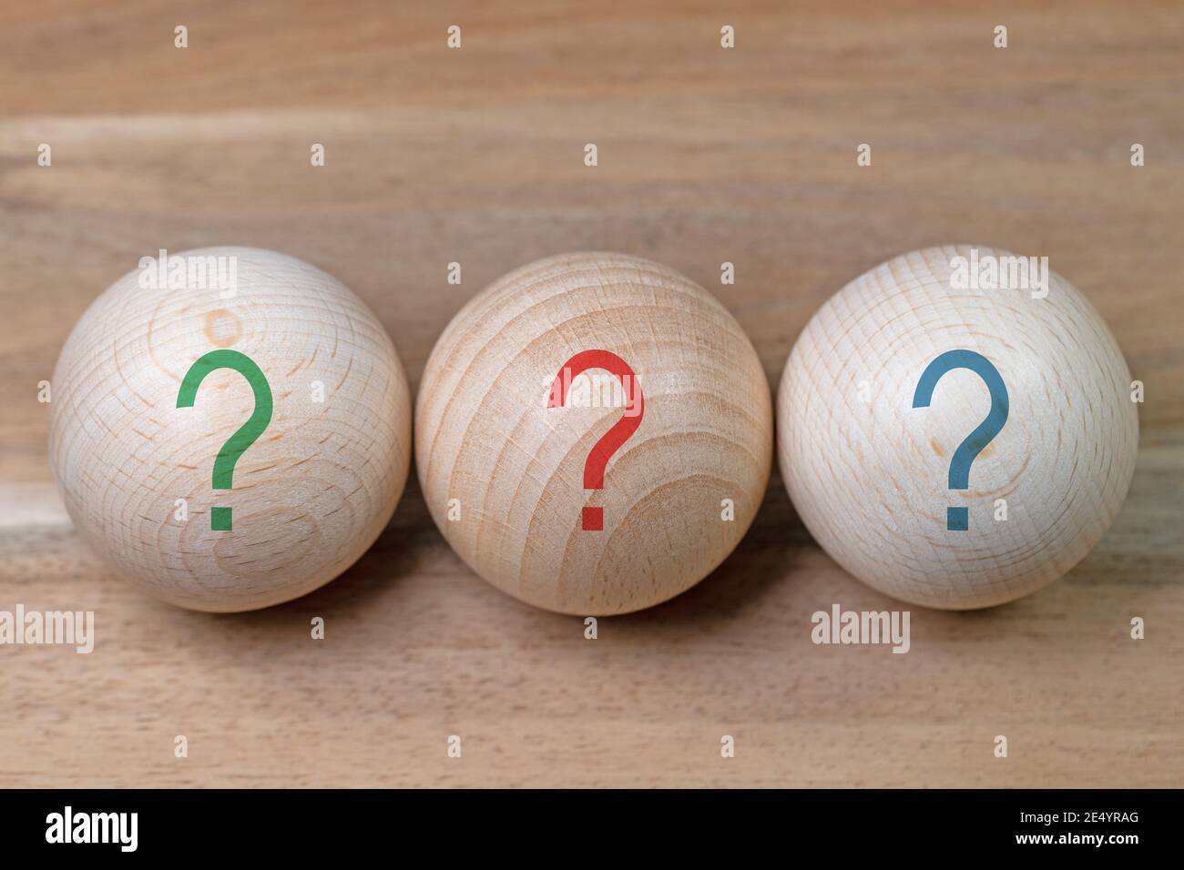Three wooden balls with printed question marks Stock Photo - Alamy
