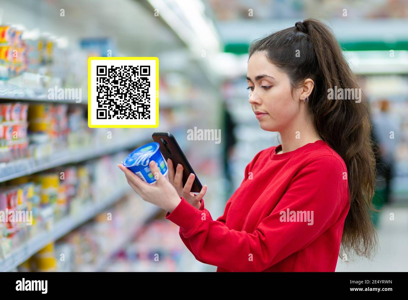 Shopping. A young pretty woman scans the qr code on a product using ...