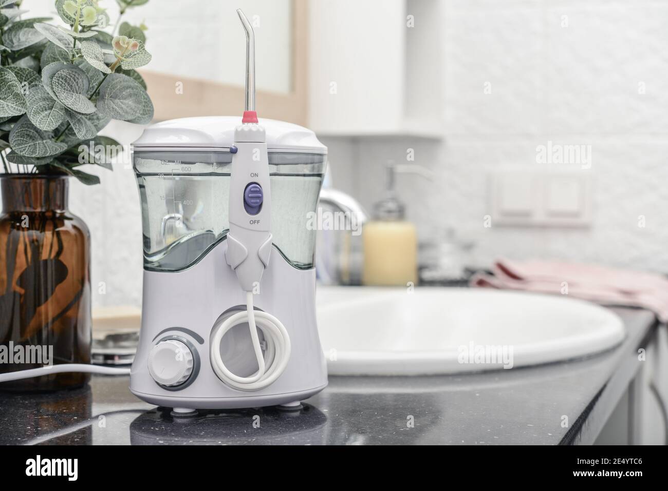 Electric oral irrigator in the white tiled bathroom closeup Stock Photo ...