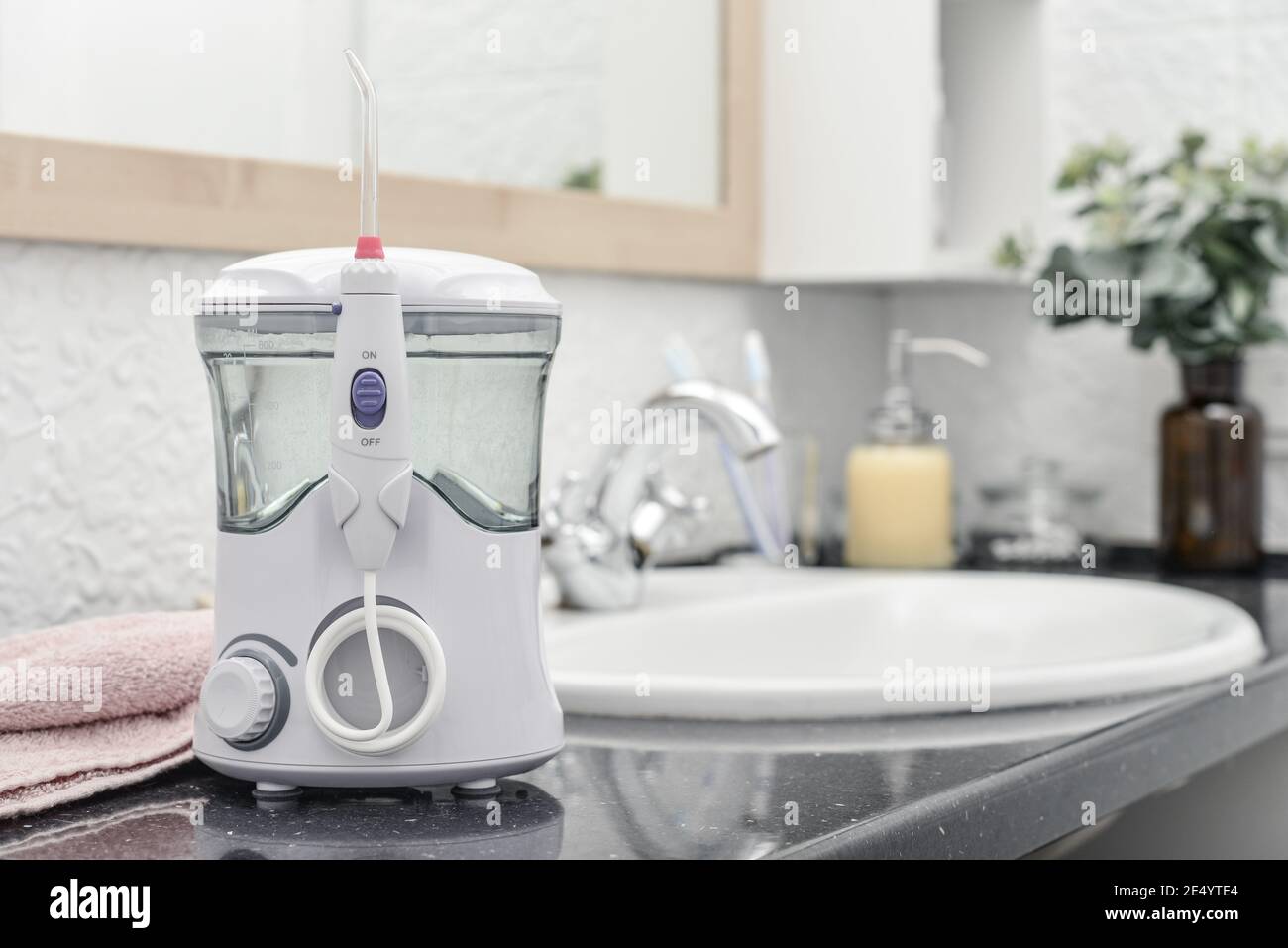 Electric oral irrigator in the white tiled bathroom closeup Stock Photo ...