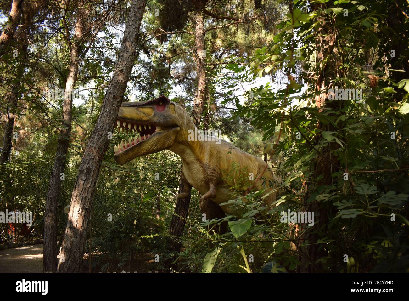Dinosaur statue in the forest park in nature for background. Realistic ...