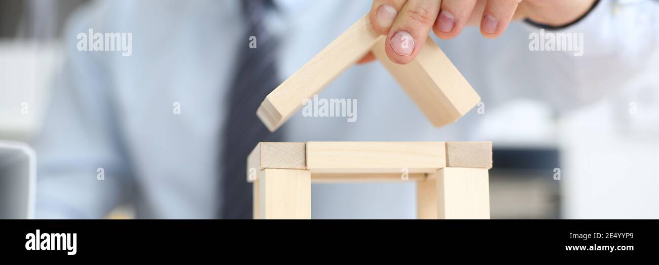 Male hand holding wooden blocks at the table Stock Photo - Alamy
