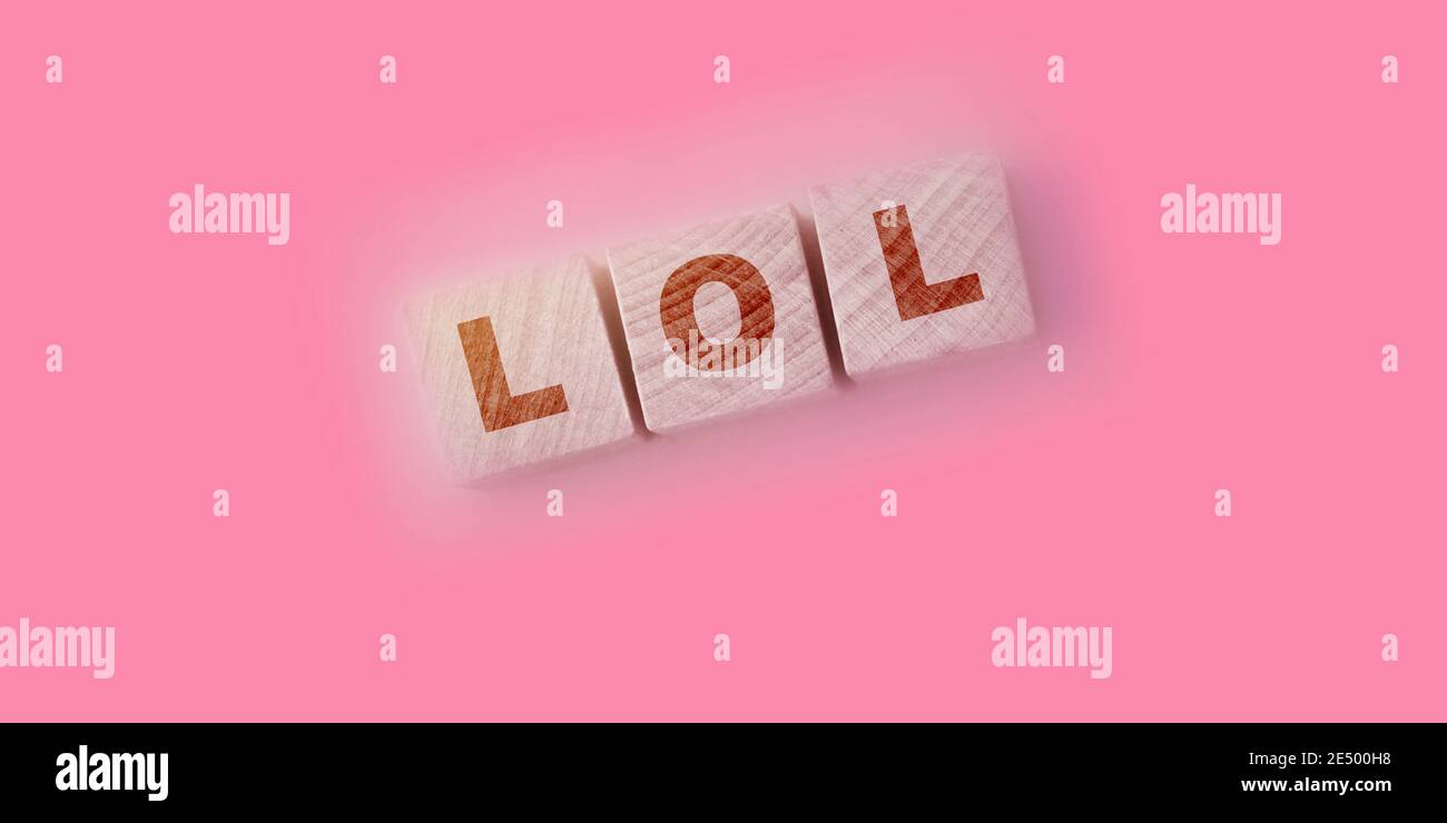 LOL abbreviation for Laughinf Out Loud on Wooden blocks on a sof pink ...