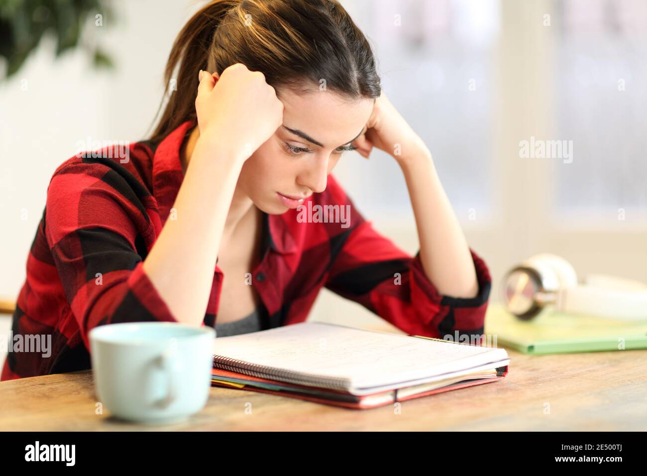 Concentrated student studying memorizing notes sitting in a table at ...