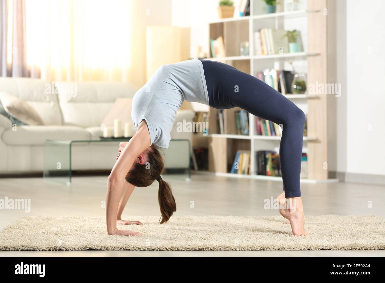 Side view portrait of a woman profile doing yoga exercise wheel pose at ...