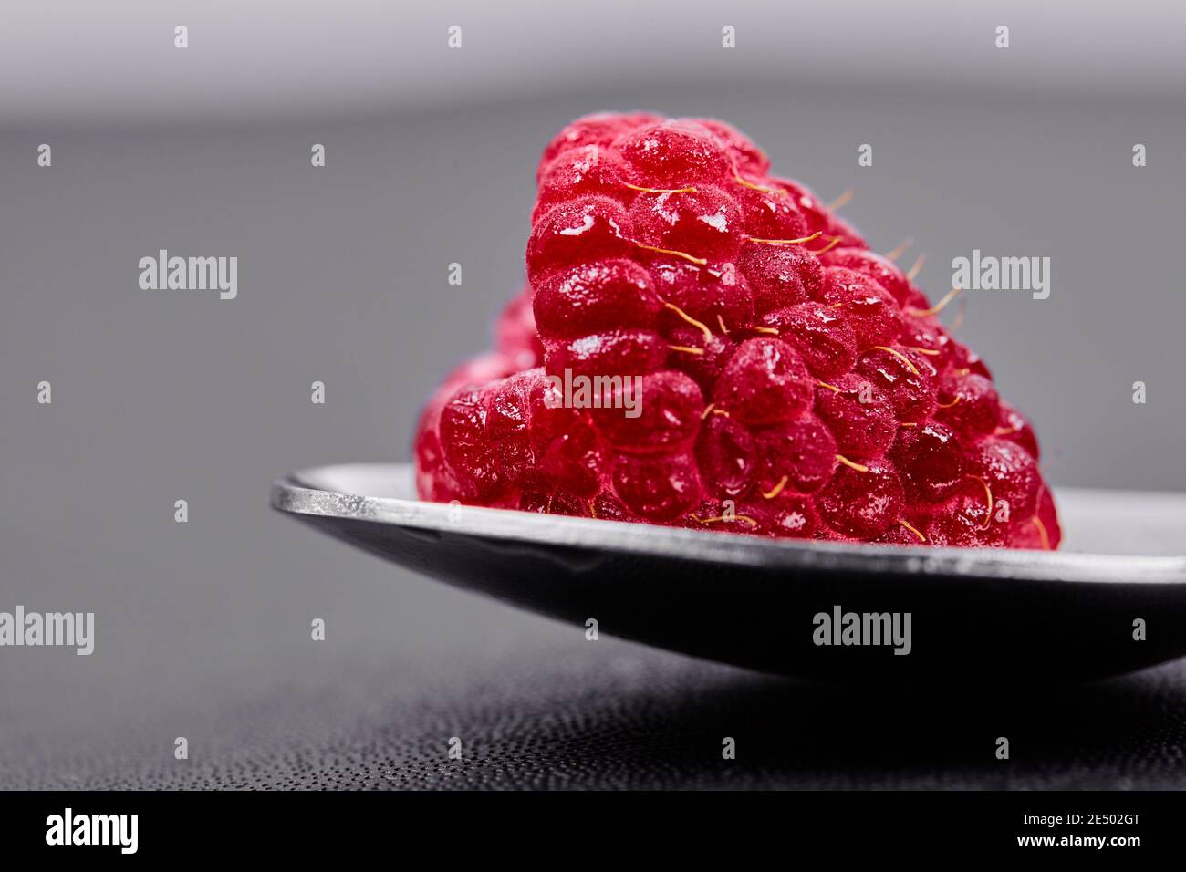 Single large raspberry on spoon. Close up Stock Photo - Alamy