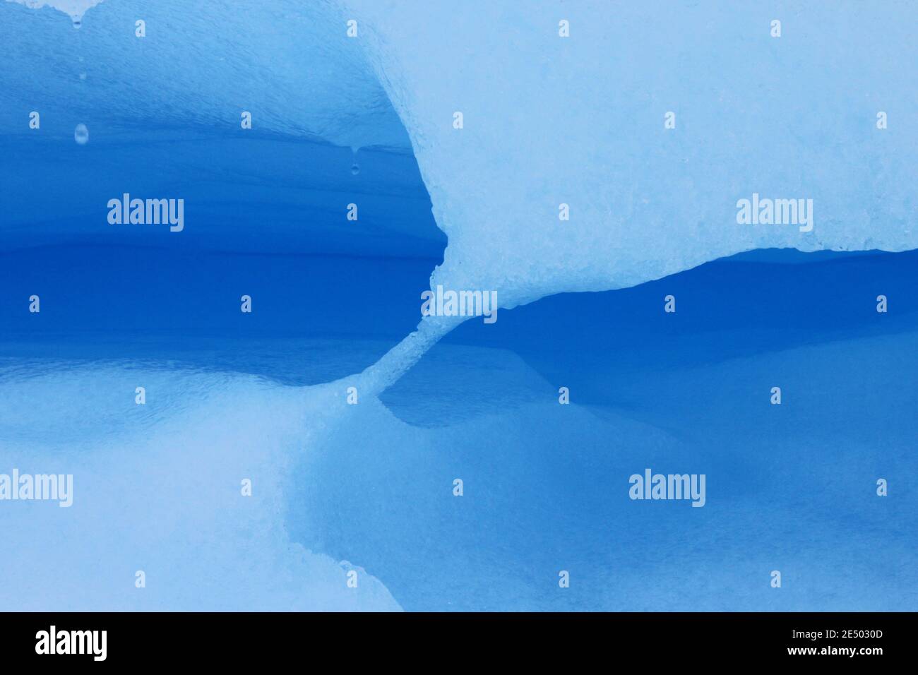 Close-up of blue ice glacier melting with dripping water drops because ...