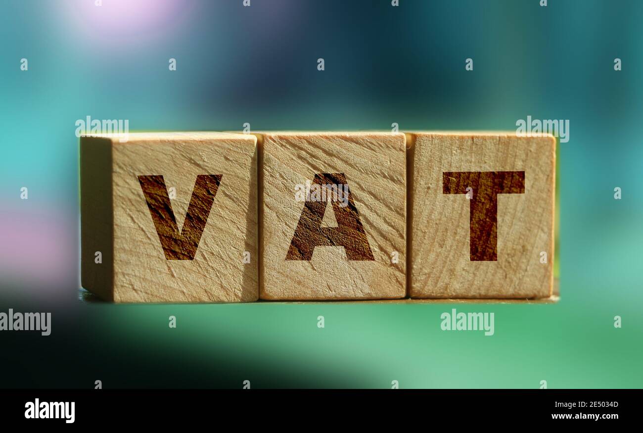 Vat abbreviation letters on wooden cubes over blur background with copy ...