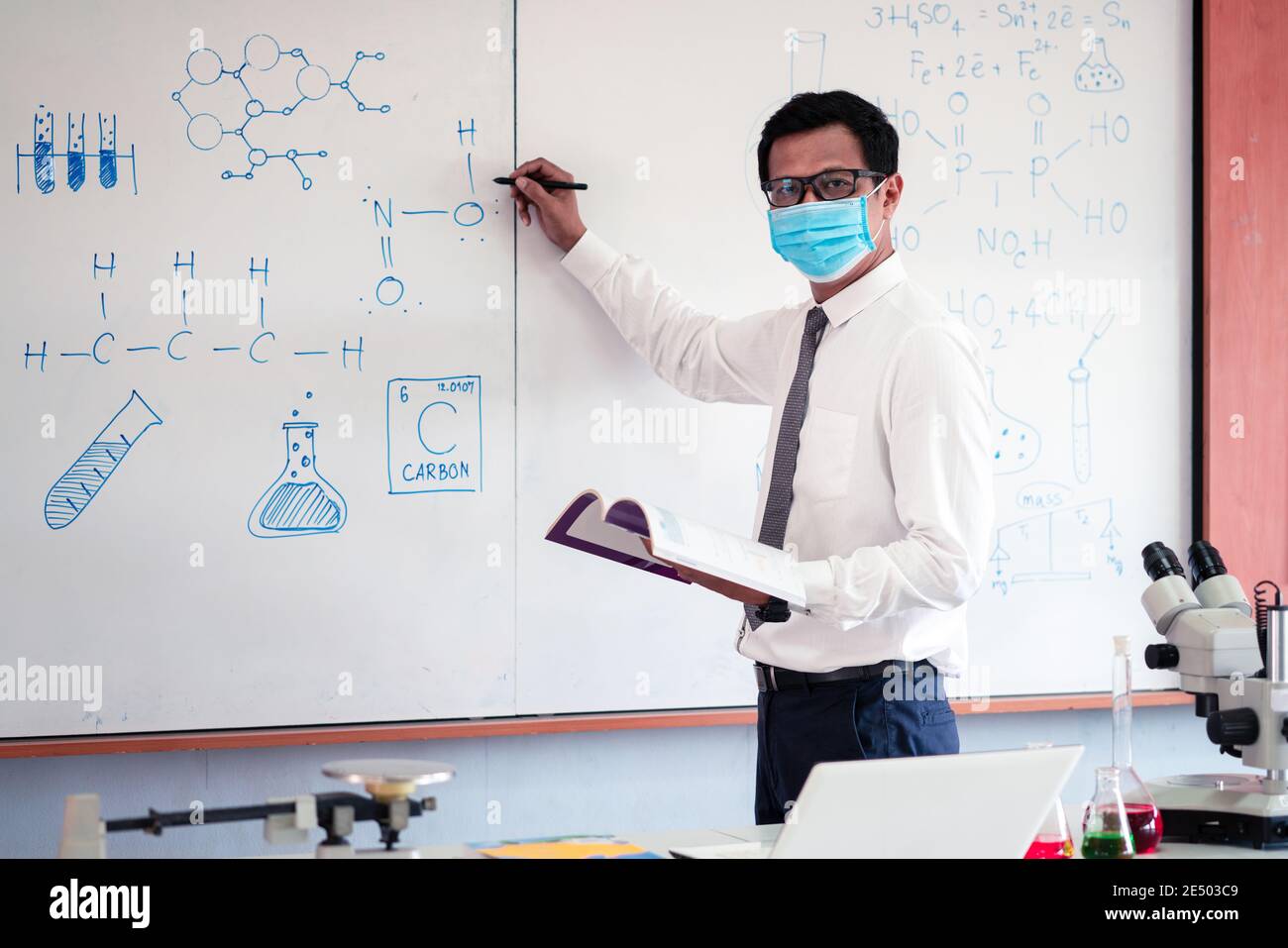 Science teacher wearing mask and teaching in the classroom Stock Photo ...