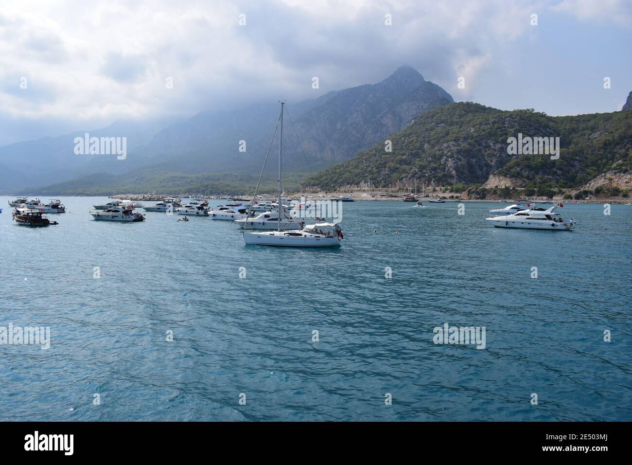 A lot of luxurious yachts cruising through beautiful blue waters near ...