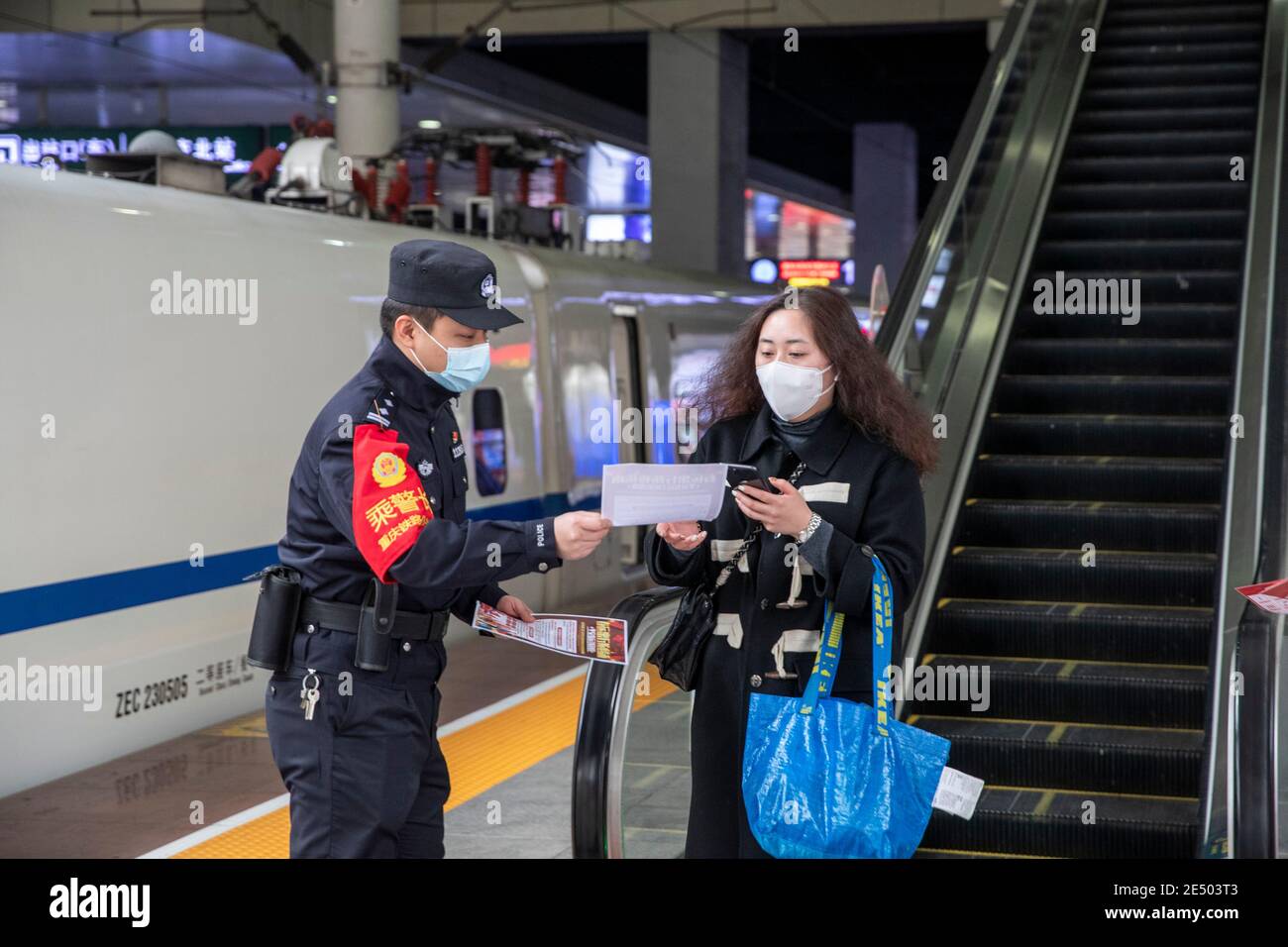 Chongqing, China. 25th Jan, 2021. A police officer distributes epidemic ...