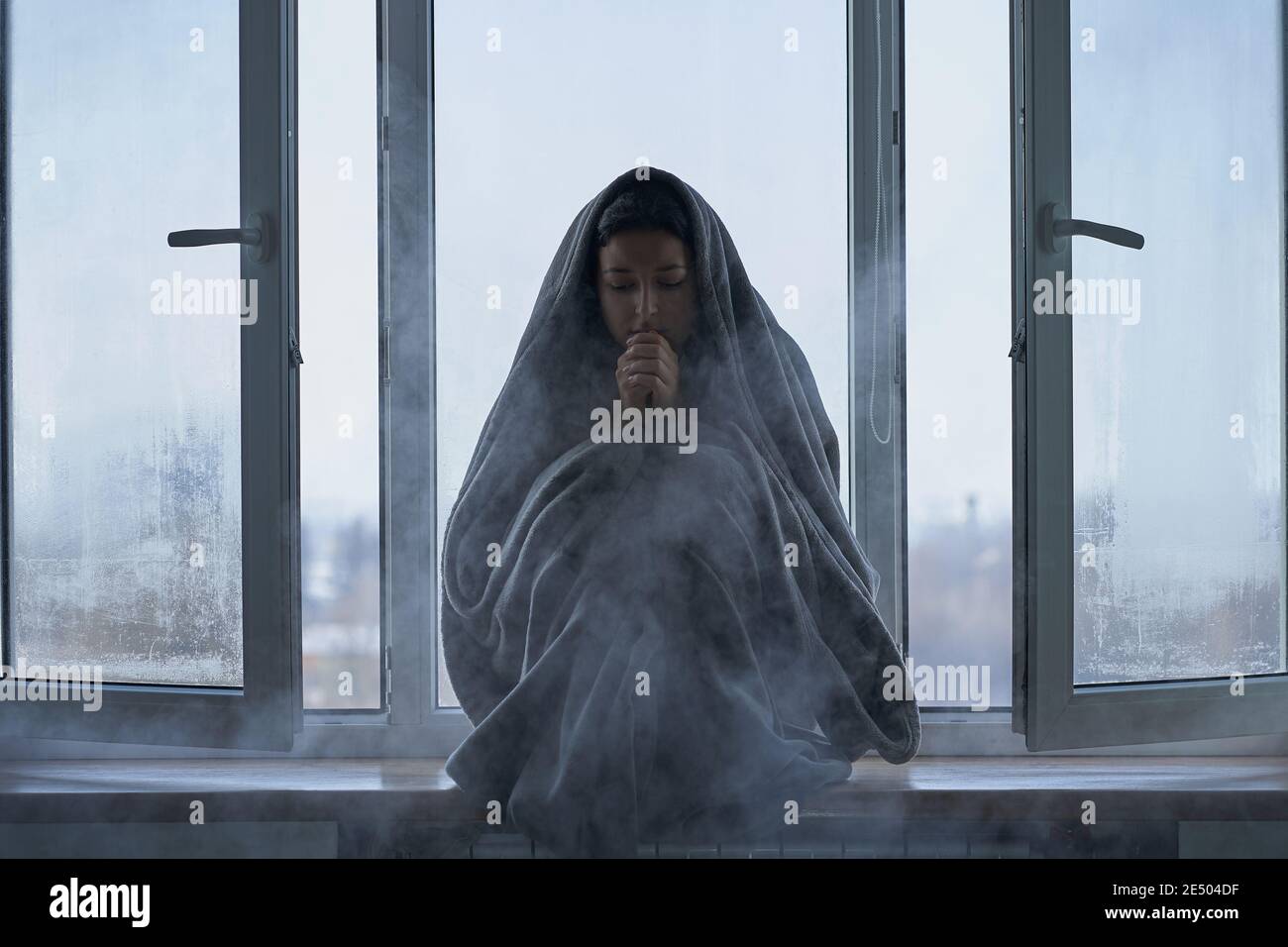 Cold winter weather. A woman is shaking from the cold sitting on the ...