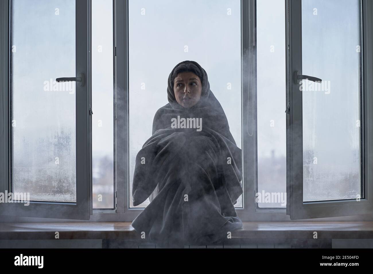 Cold winter weather. A woman is shaking from the cold sitting on the ...