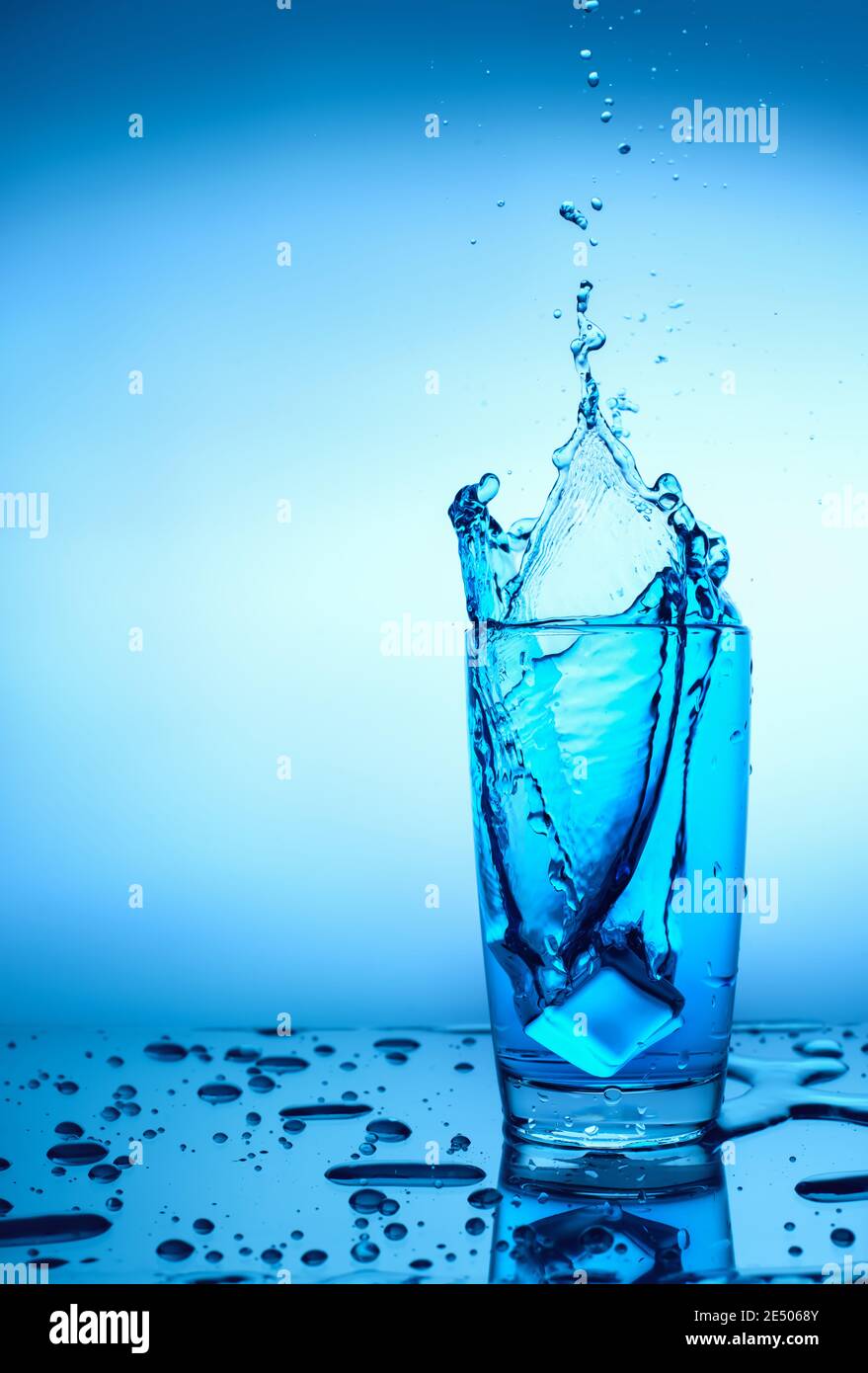 ice cube falls into a glass of water. splash Stock Photo - Alamy