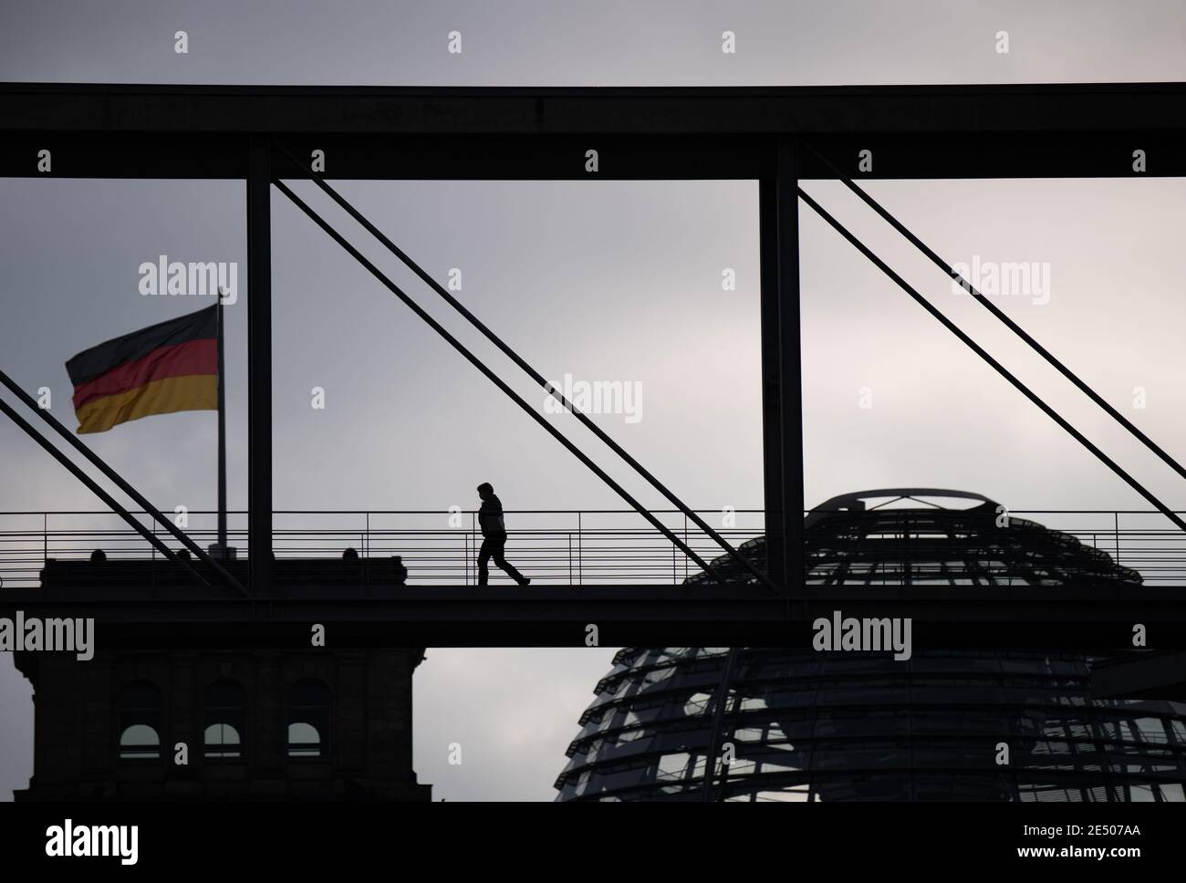 Berlin, Germany. 25th Jan, 2021. A pedestrian walks across a bridge ...