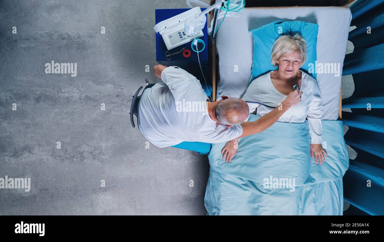 Top view of doctor with stethoscope examining patient in bed in ...