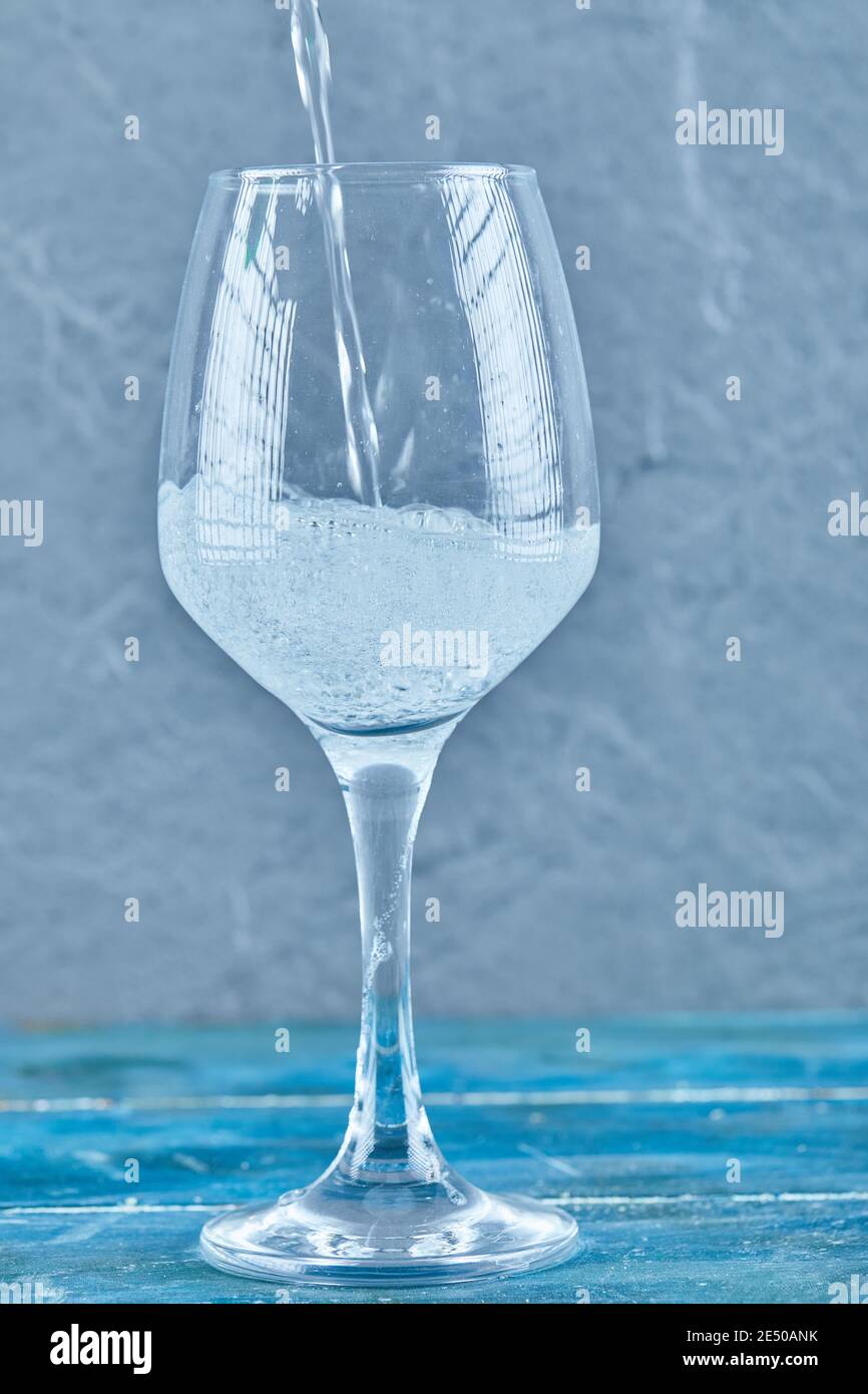 A glass of sparkling water on blue background Stock Photo - Alamy