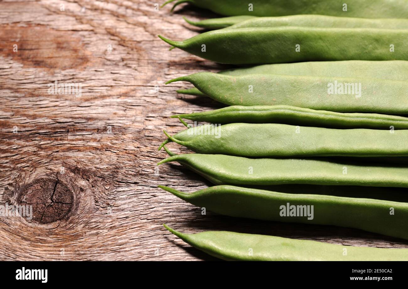 Piattoni green beans isolated on wooden background. Taccole. Top view ...