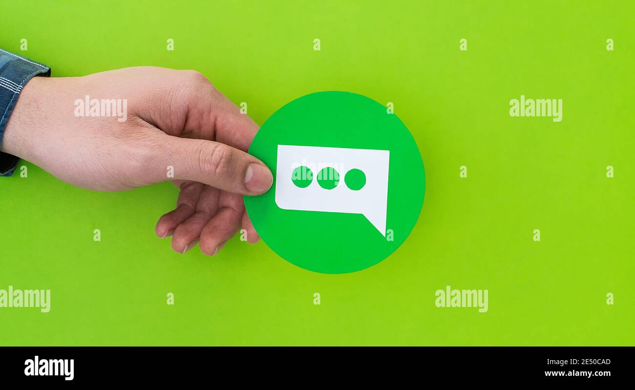 Closeup of a person holding a typing bubble isolated on a green ...