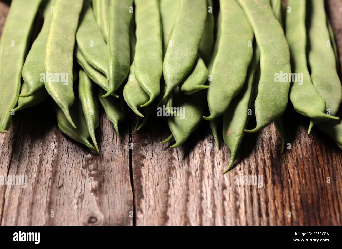 Piattoni green beans isolated on wooden background. Taccole. Top view ...