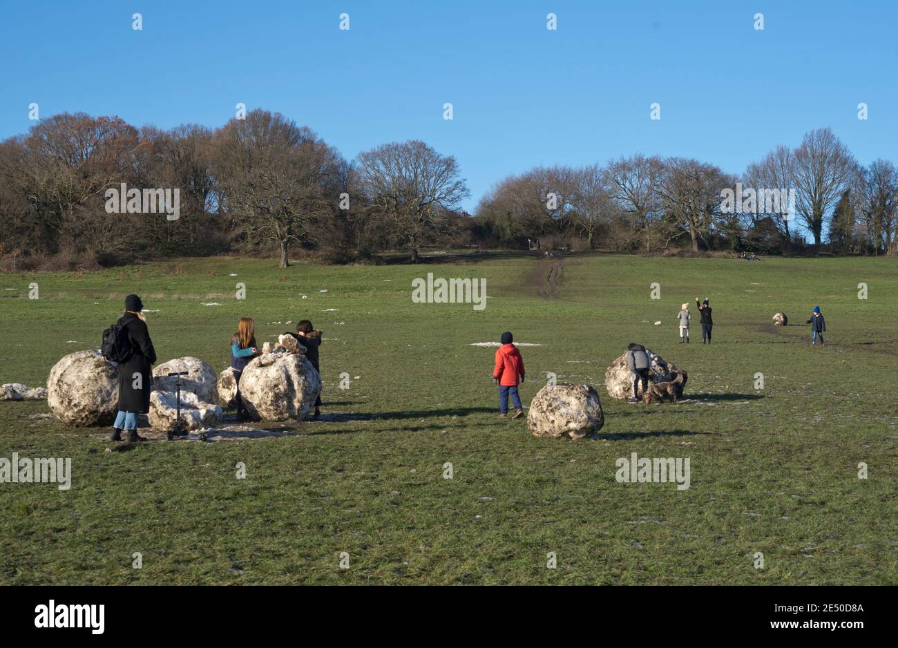 Families with children playing in the winter snow at Hampstead Heath ...