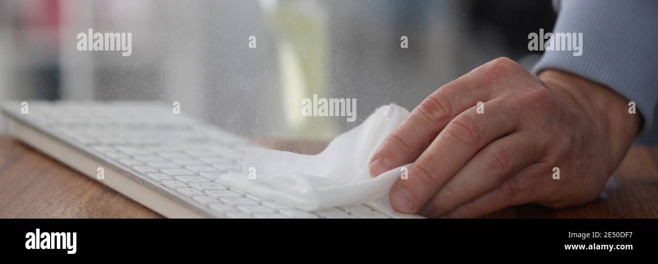 Male hand wiping computer keyboard with antiseptic napkin close-up ...