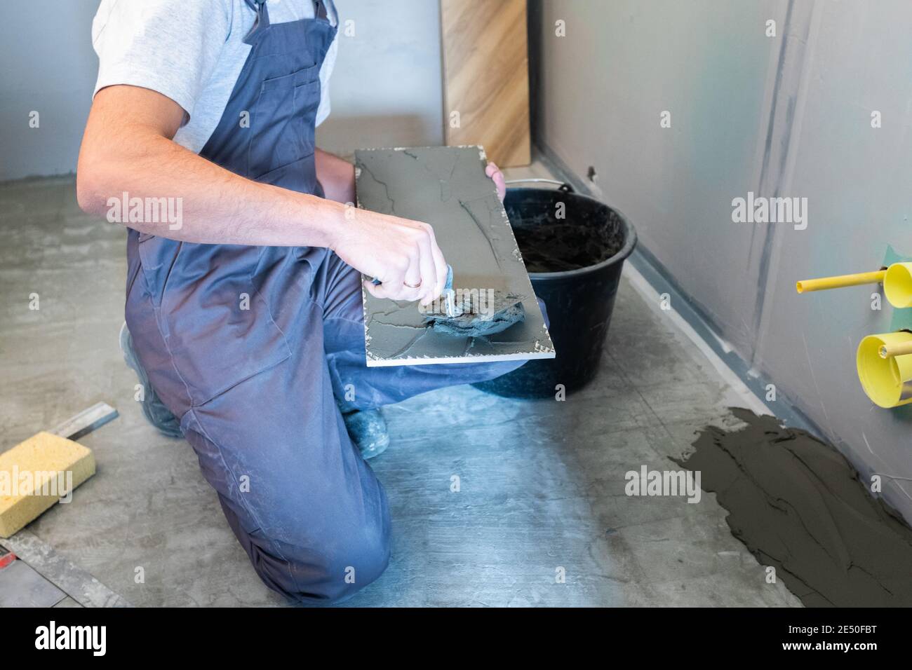 The process of laying ceramic floor tiles with a herringbone pattern ...