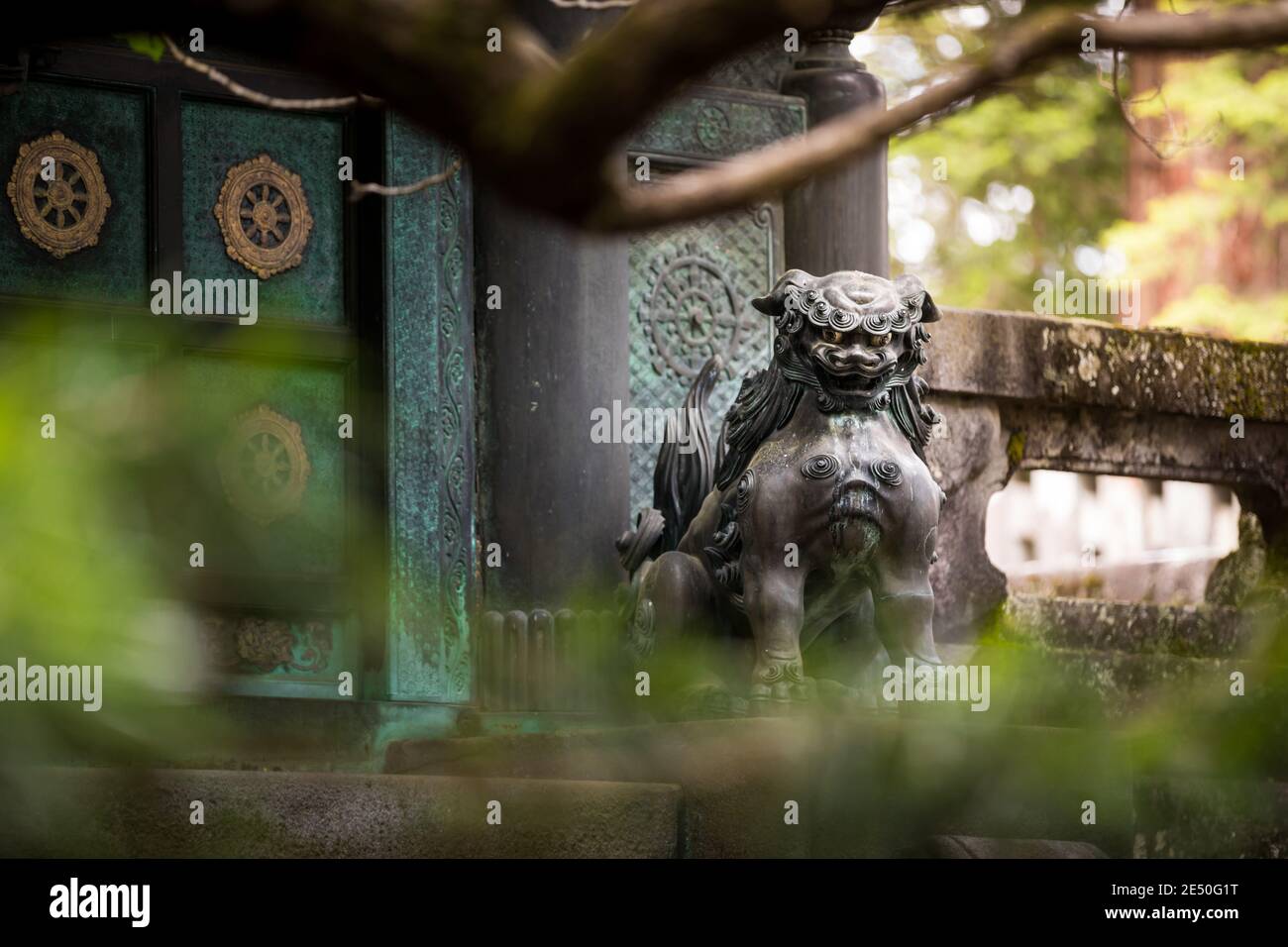 Close up of a bronze statue of a japanese lion in front of temple ...
