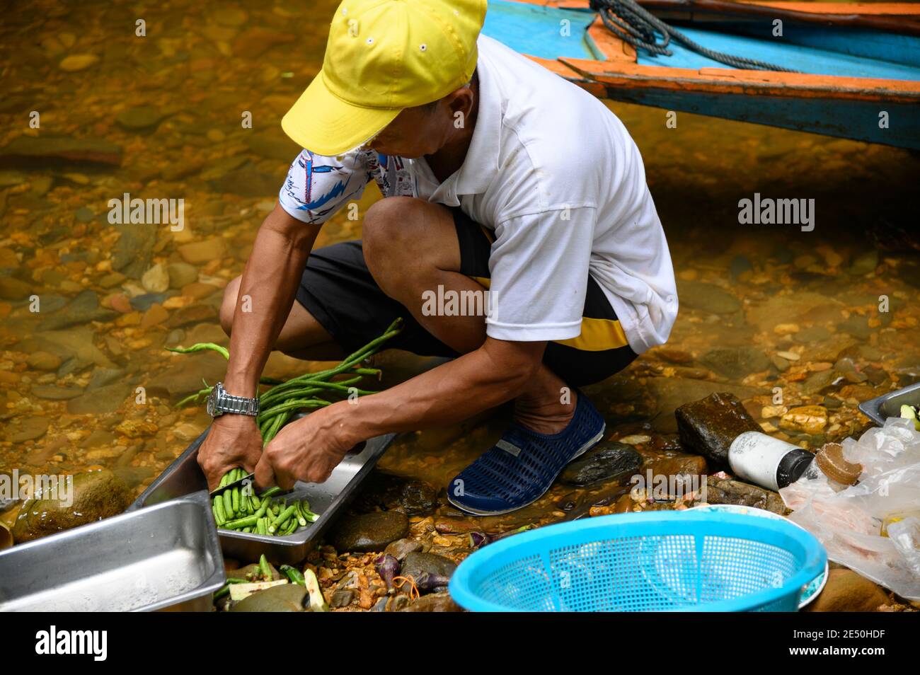 man cutting long beans to be steamed over open fire Stock Photo - Alamy
