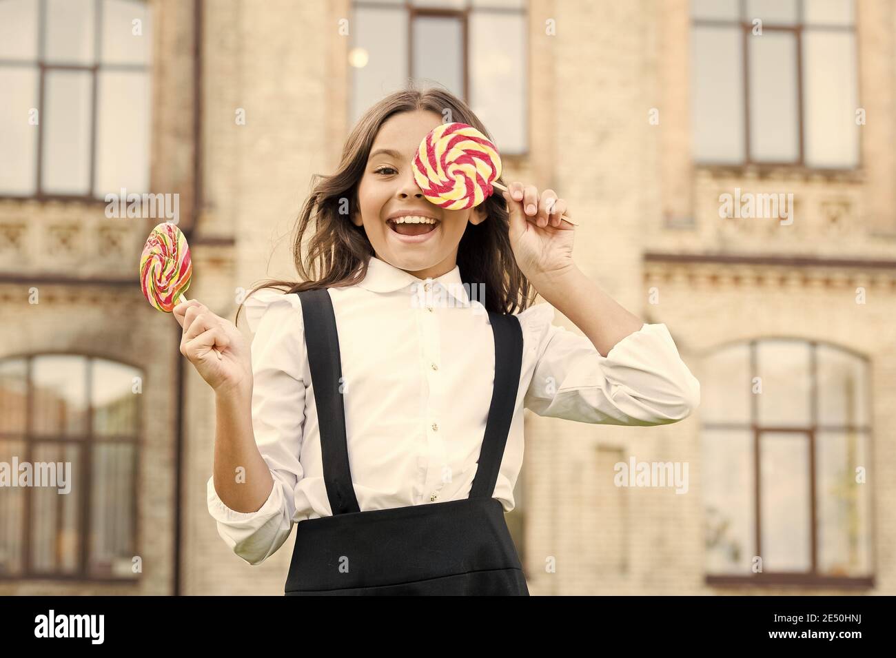 Cheat meal day. Happy kid with sweet candy. Kid child holding lollipops ...