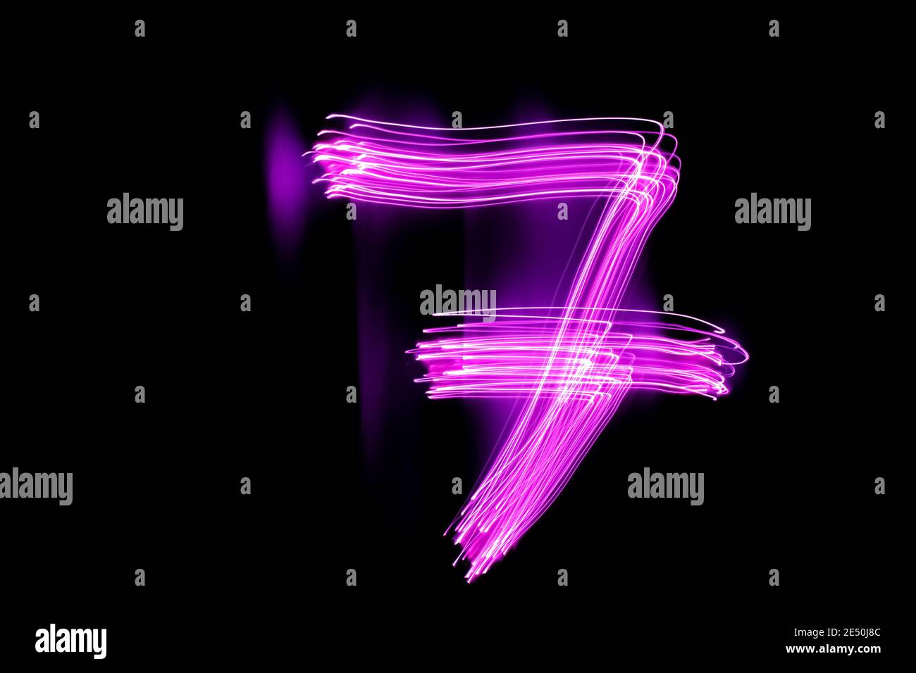 Long exposure photography. Writes 7 with pink light on black background ...