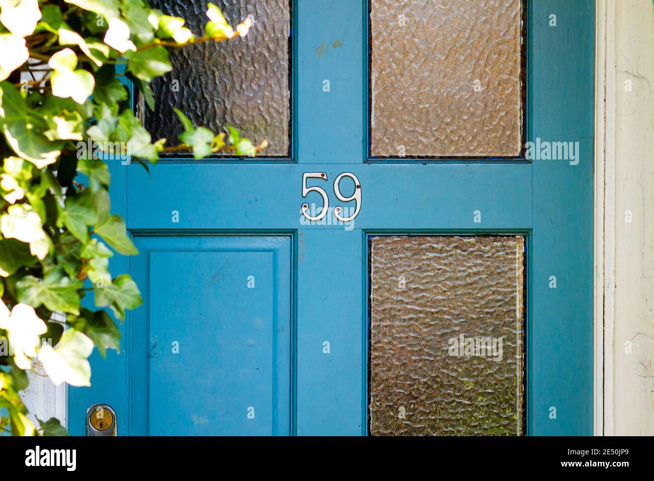 Number 59 on an old wooden front door with glass panels Stock Photo - Alamy