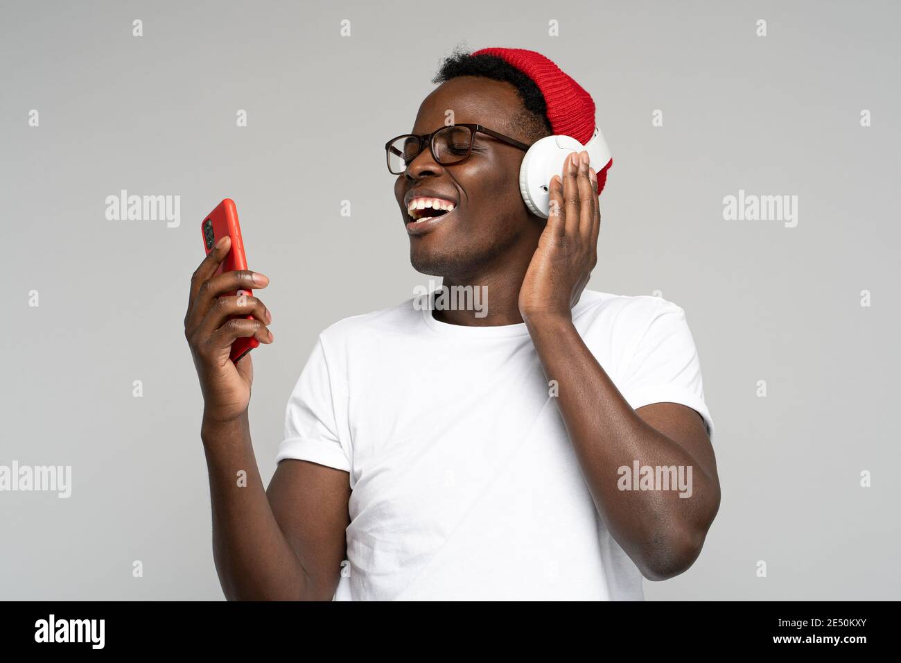 Happy afro man wear wireless headphones enjoying listening to music ...