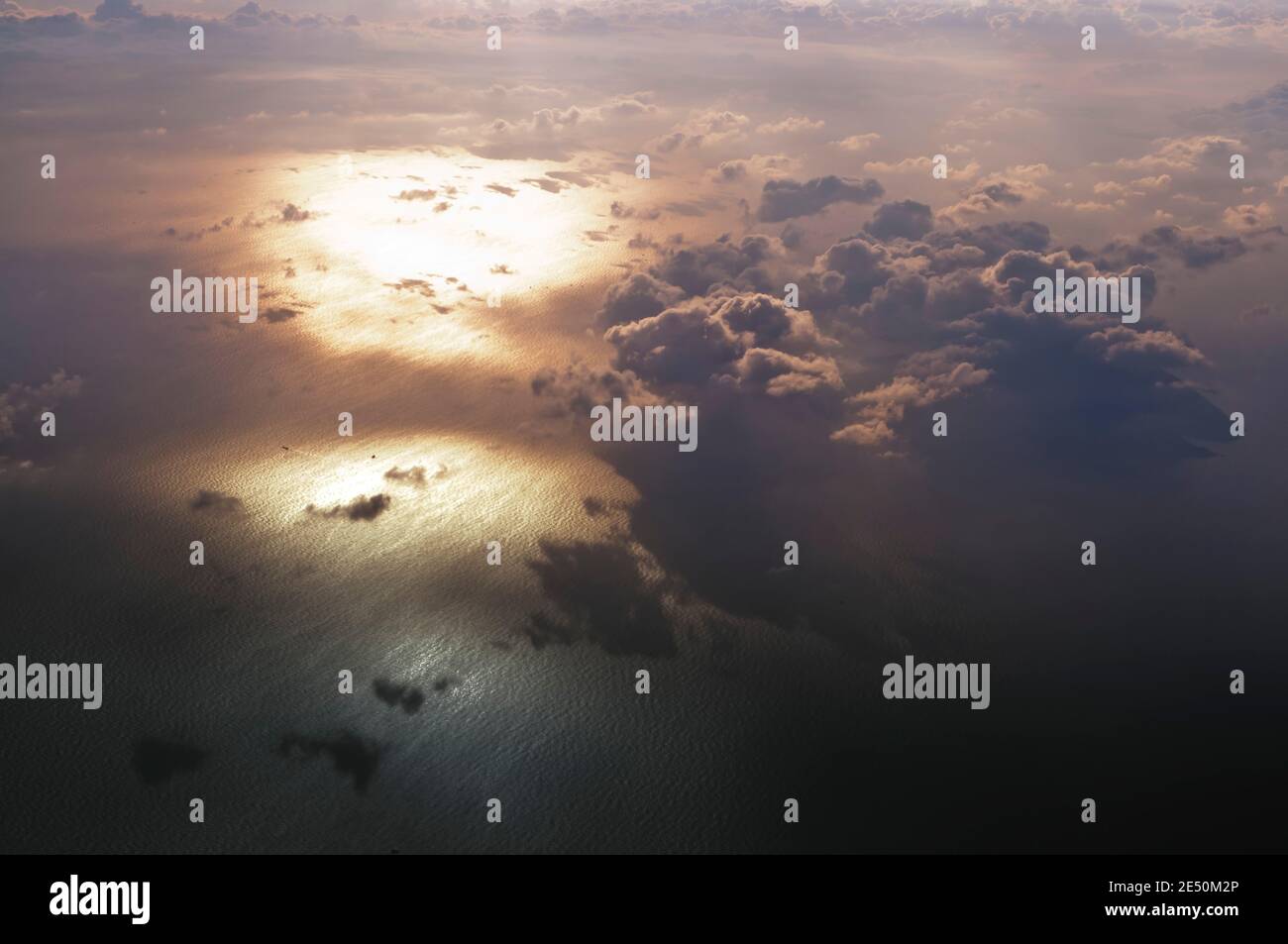 Aerial view of the land below as seen from high altitude, with fluffy ...