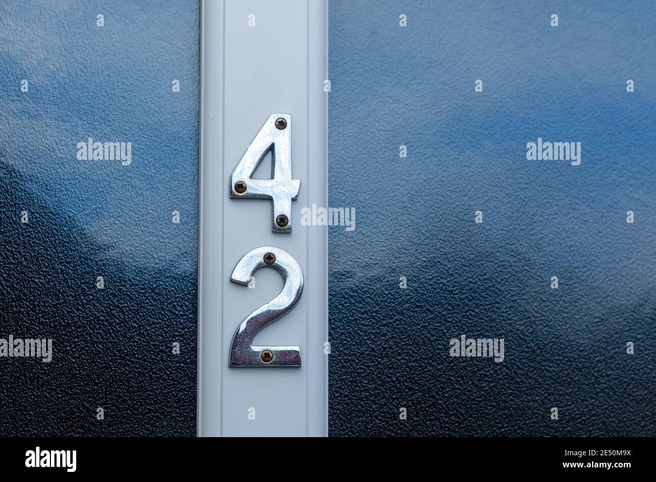 Number 42 in shiny metal digits on a white door with frosted glass ...