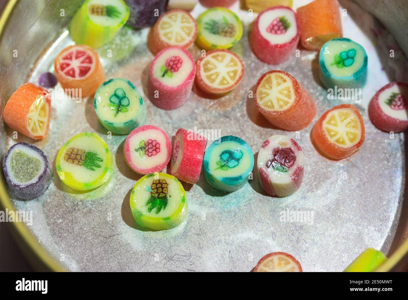 Half-empty tin can with multicolored lollipops with different flavors ...