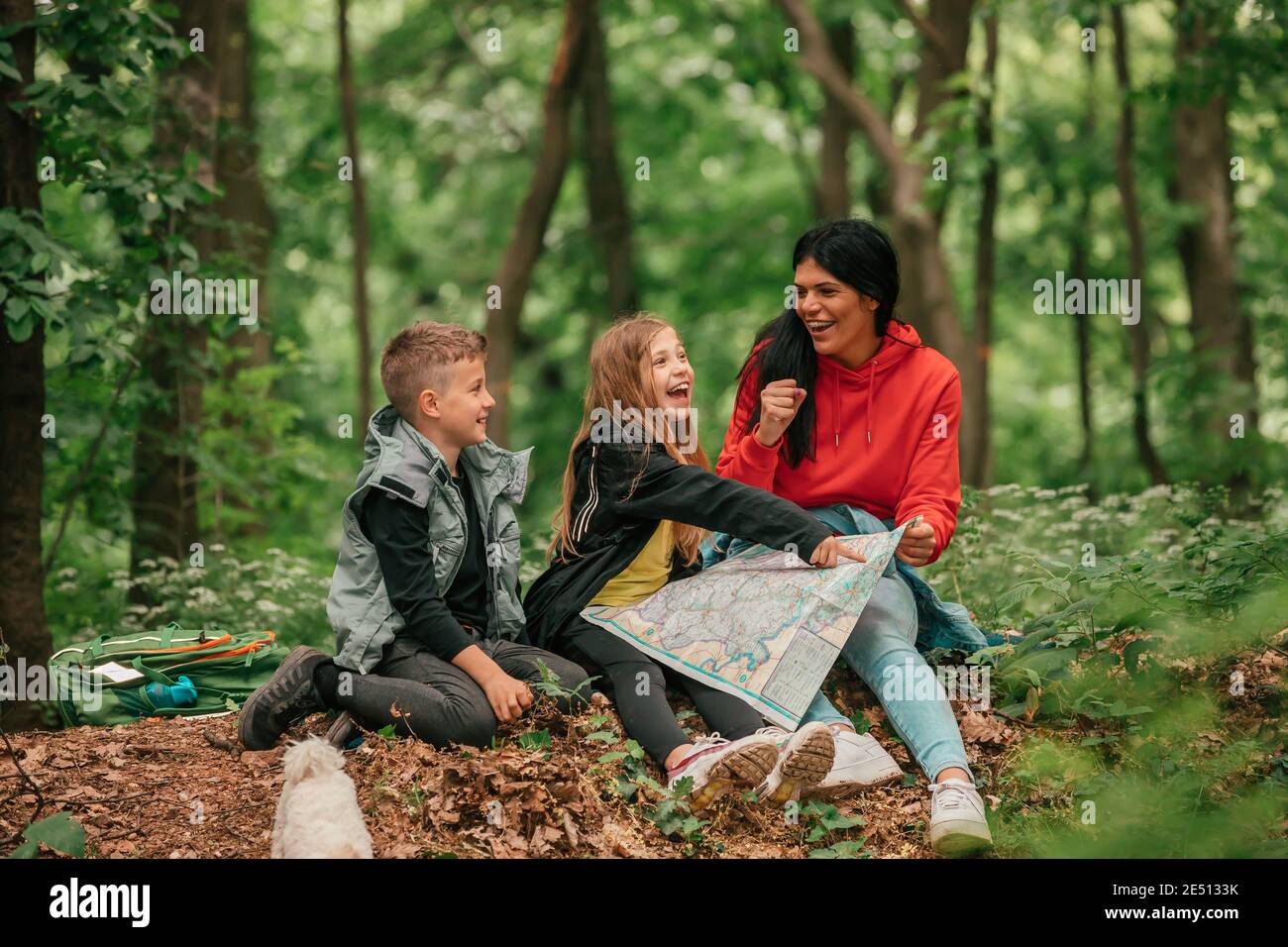 Beautiful mother with two kids are having break in the forest, using a ...