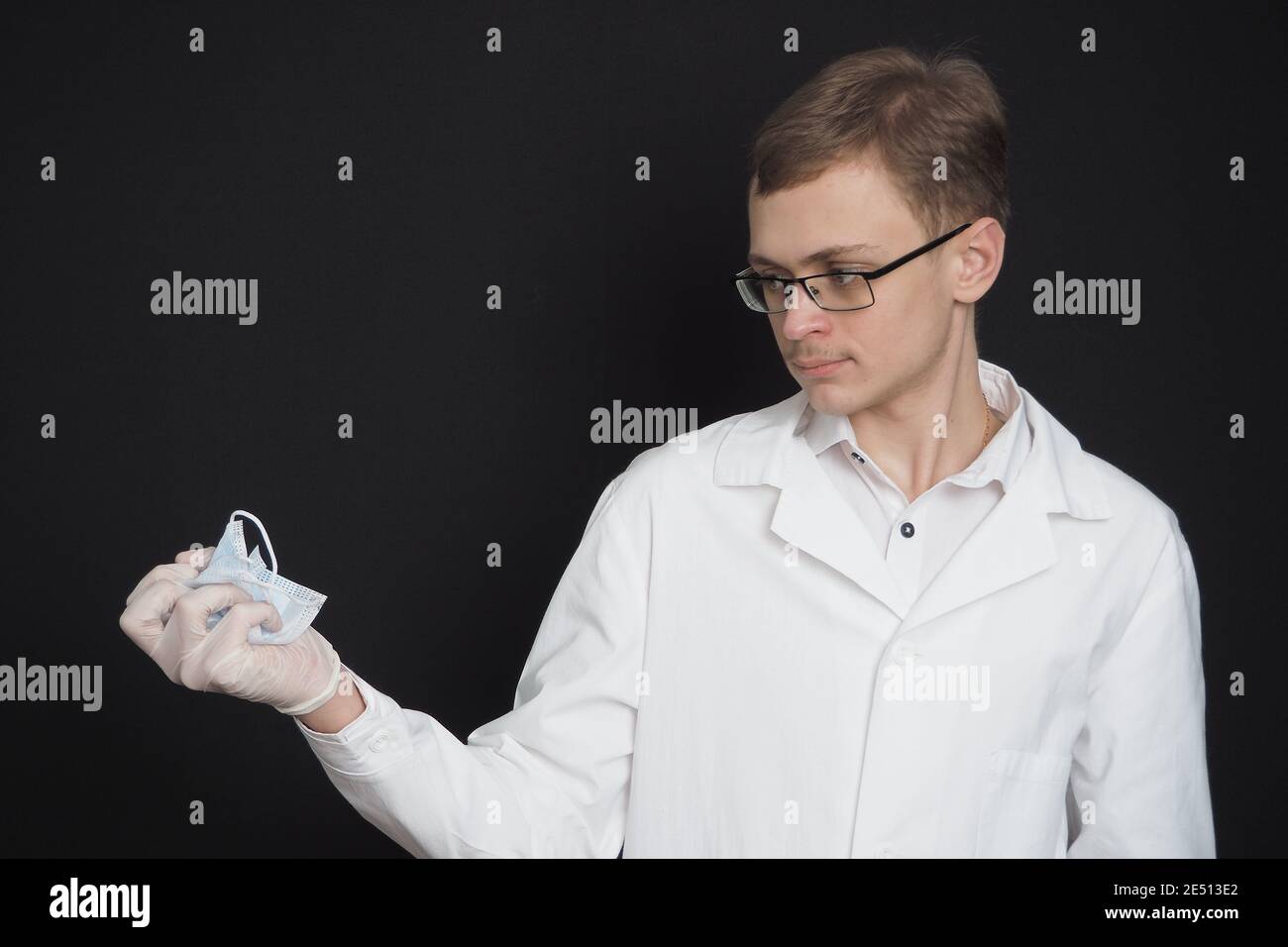 Portrait of a young doctor of European appearance in a white medical ...