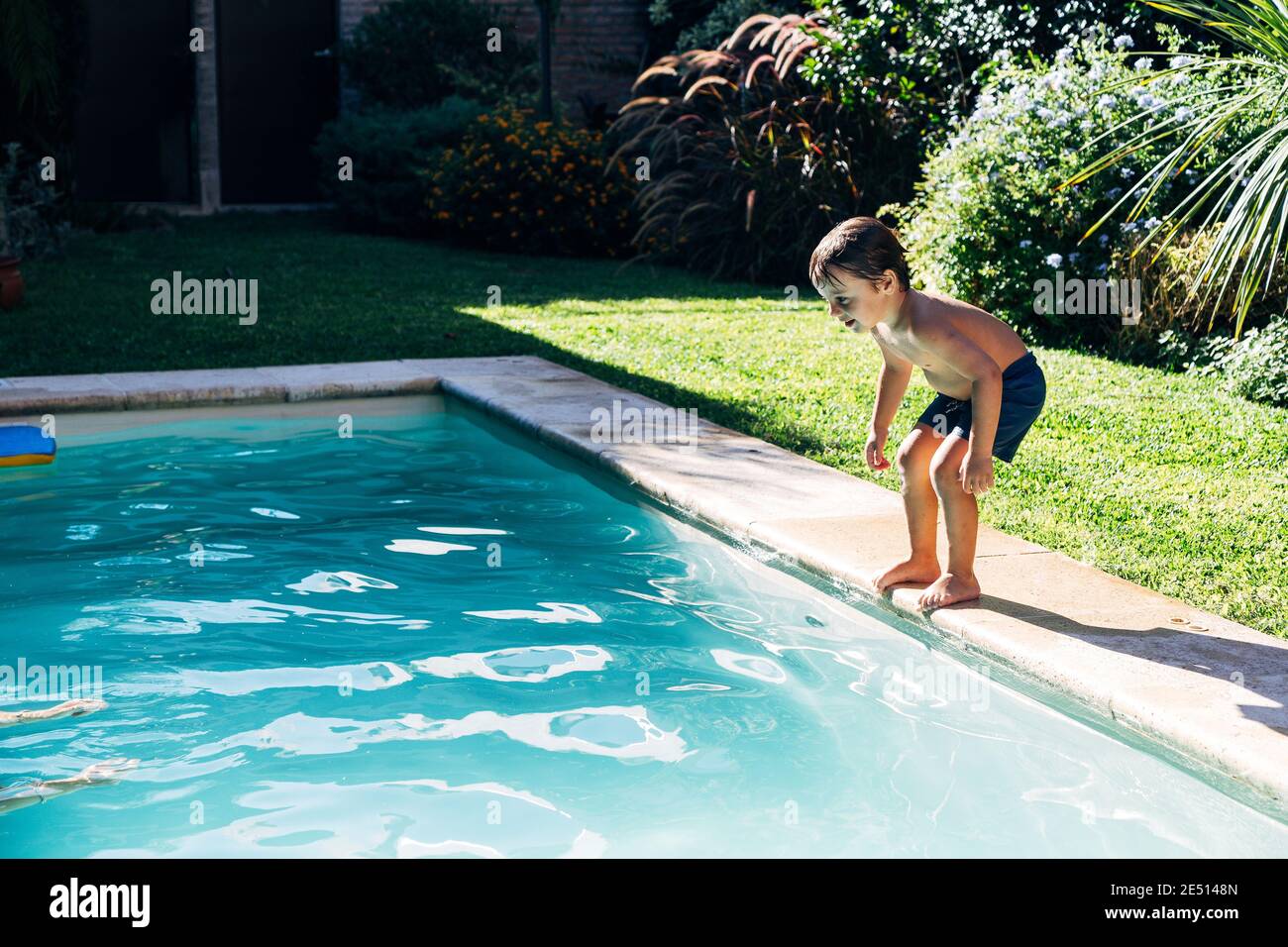 Little boy jumping in a pool. Child get fun in the swimming pool of his ...