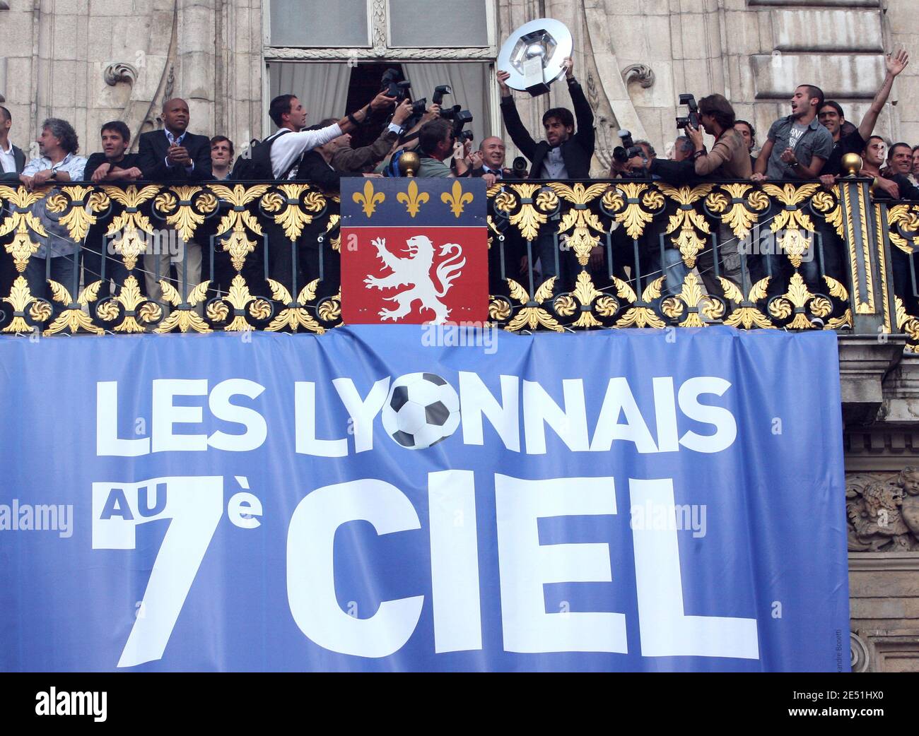 Lyon's Juninho holds the trophy on the balcony of City Hall in front of ...