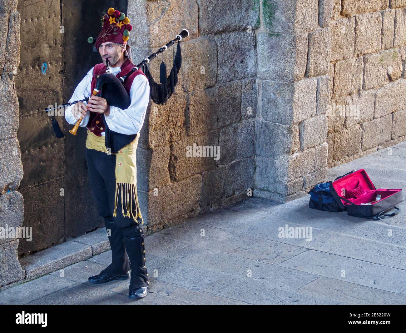 Camino pilgrims are welcome by a Galician bagpipes player busking under ...