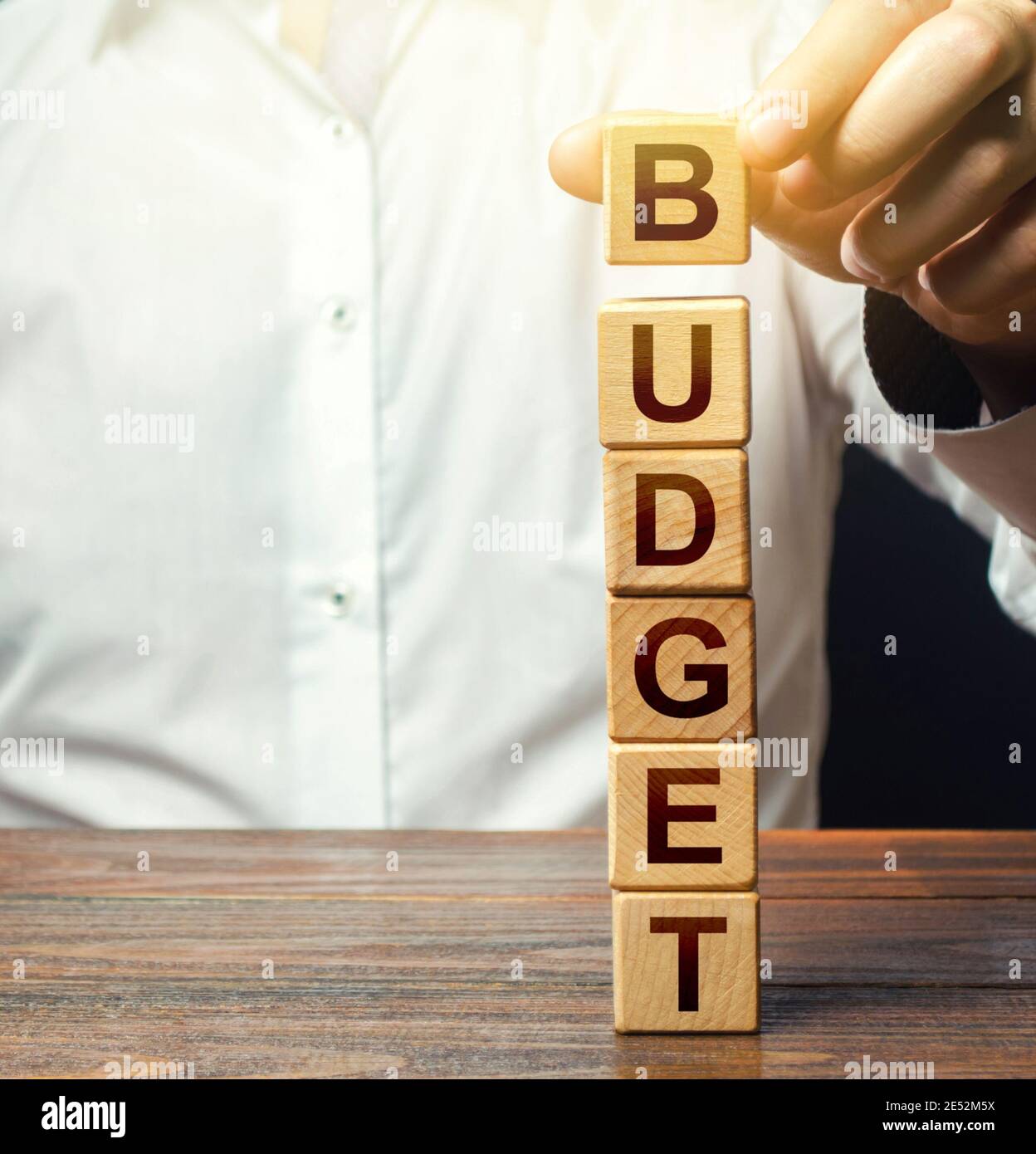Man builds a tower of blocks with word Budget. Budgeting, forecasting ...