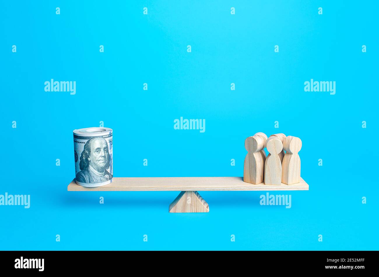 Wooden people and a bundle of dollars on the scales. Reducing the cost ...