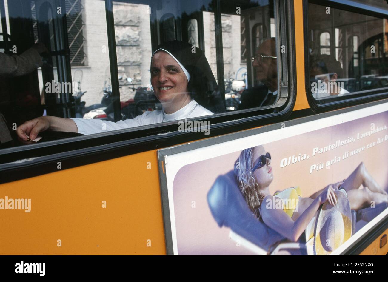 Italy Rome Nun sitting in bus with advertisement od woman in bikini ...