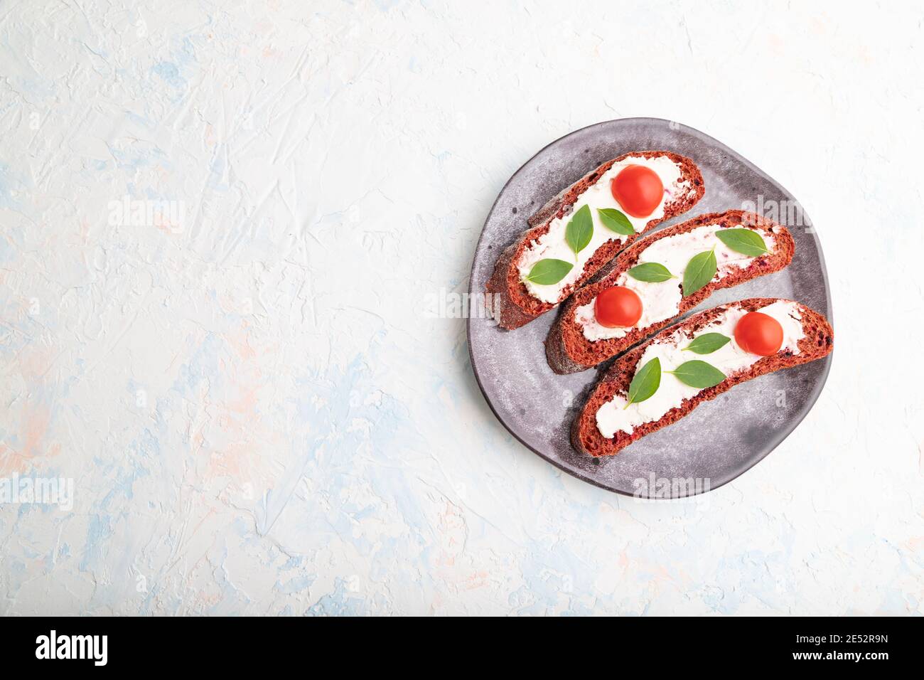 Red beet bread sandwiches with cream cheese and tomatoes on white ...