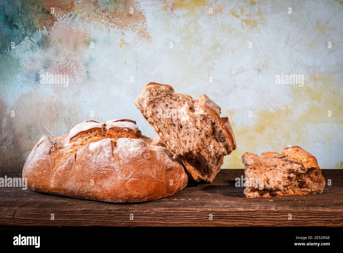 Country bread with floured crust with pieces of crumb on a barn wood ...