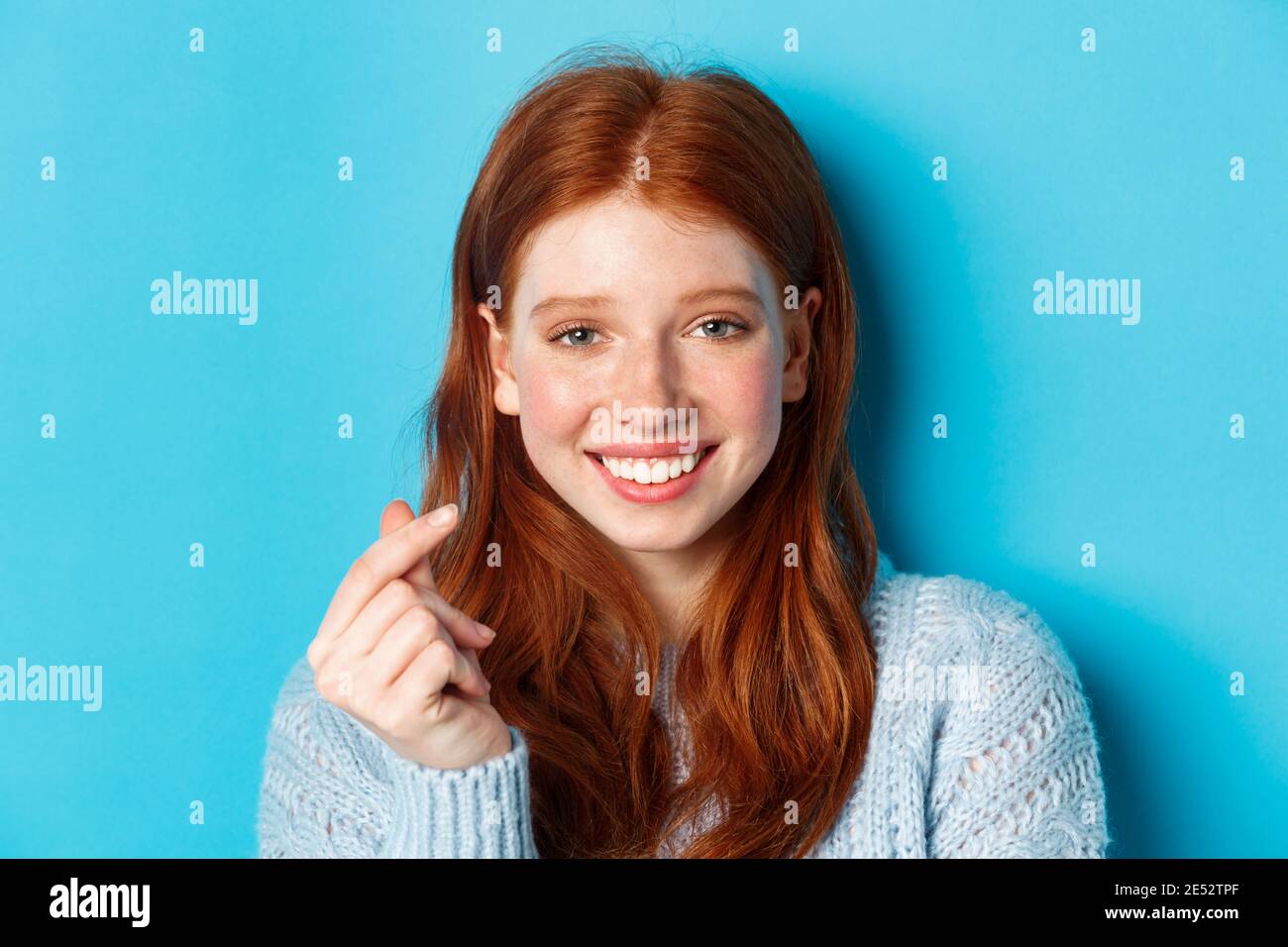 Headshot of cute caucasian woman with red hair and freckles showing ...