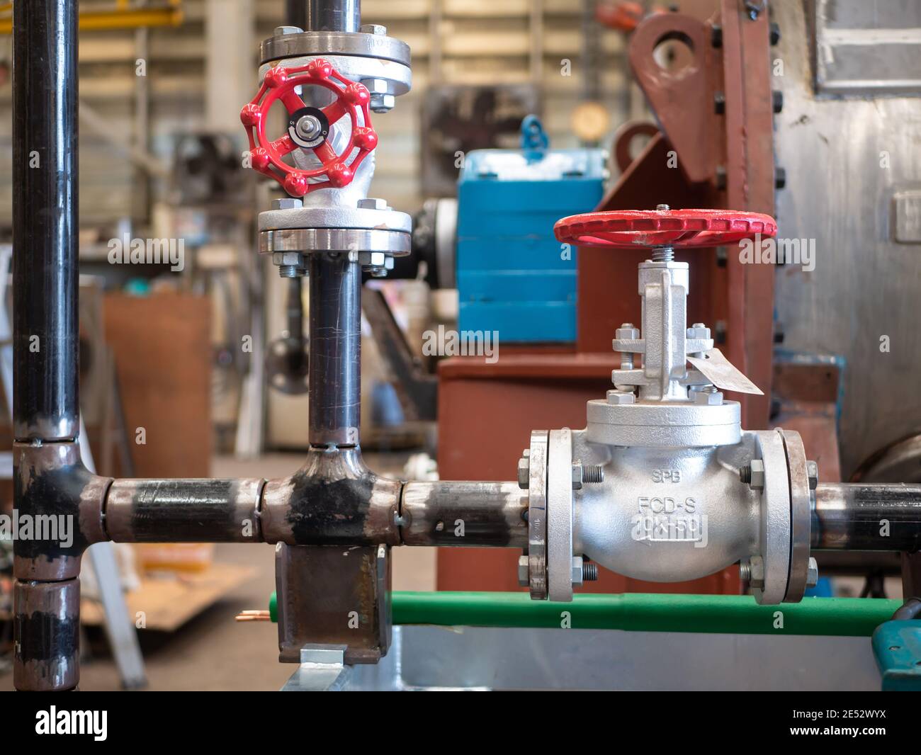 Pipes with valves being welded together at an industrial workshop Stock ...