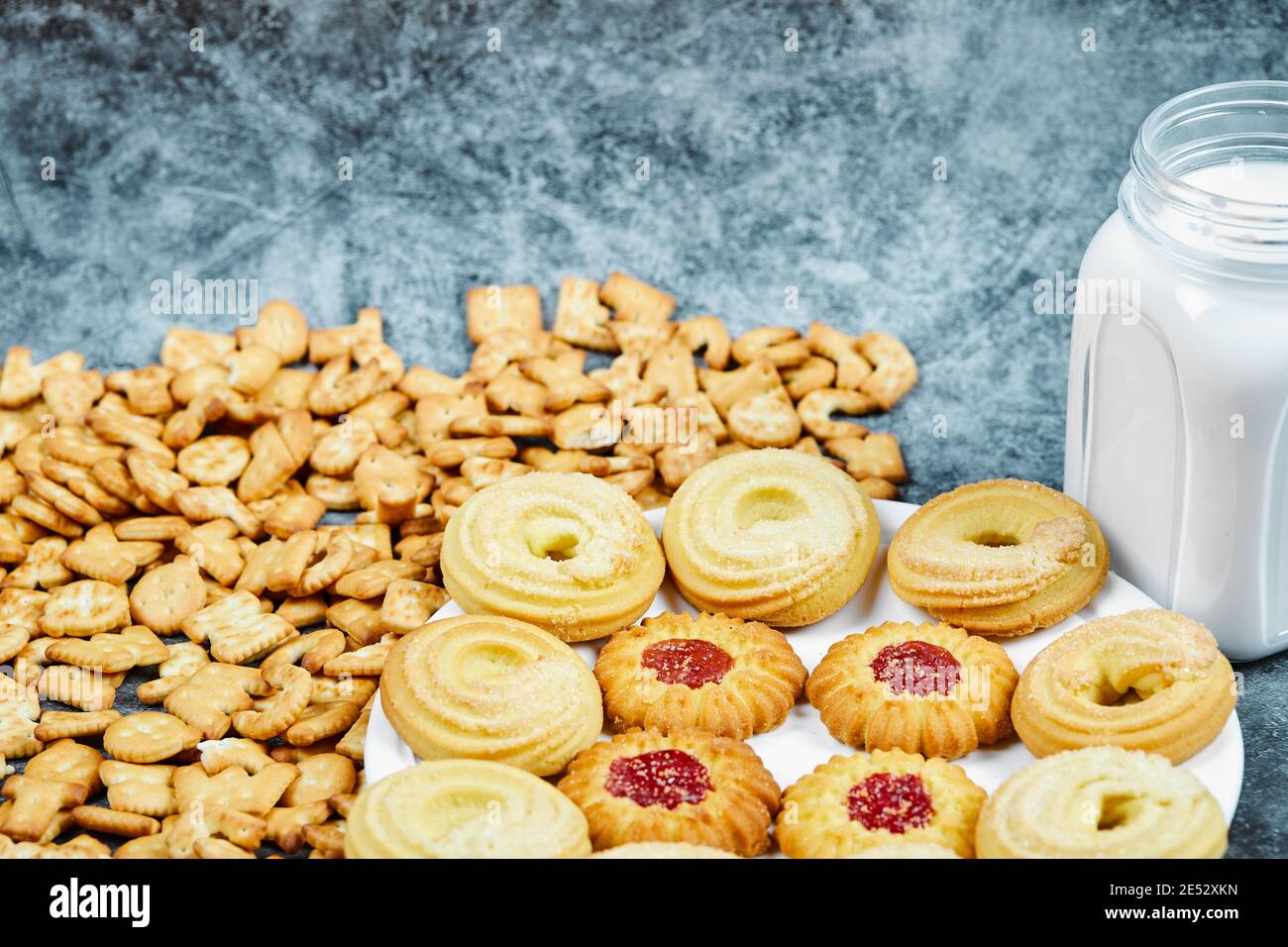 Cookie and cracker varieties with a jar of milk Stock Photo - Alamy