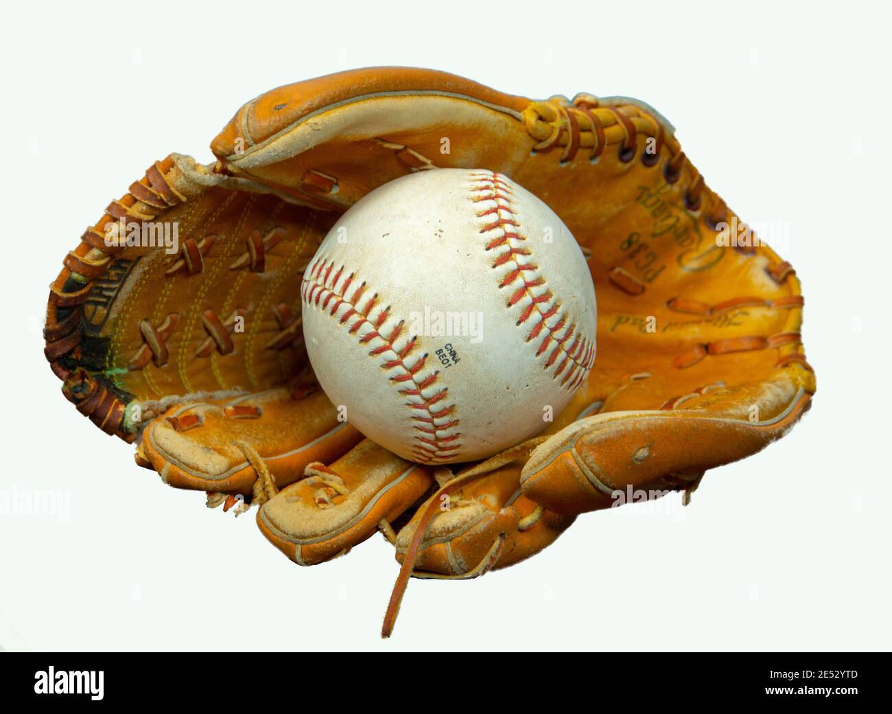 Softball laying in a baseball or softball glove with visible seams ...
